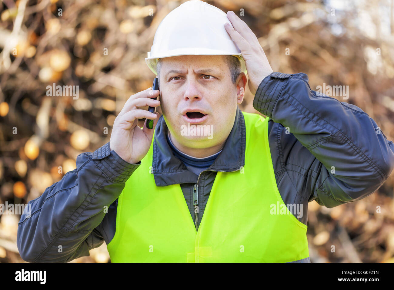 Surprised worker with cell phone Stock Photo - Alamy