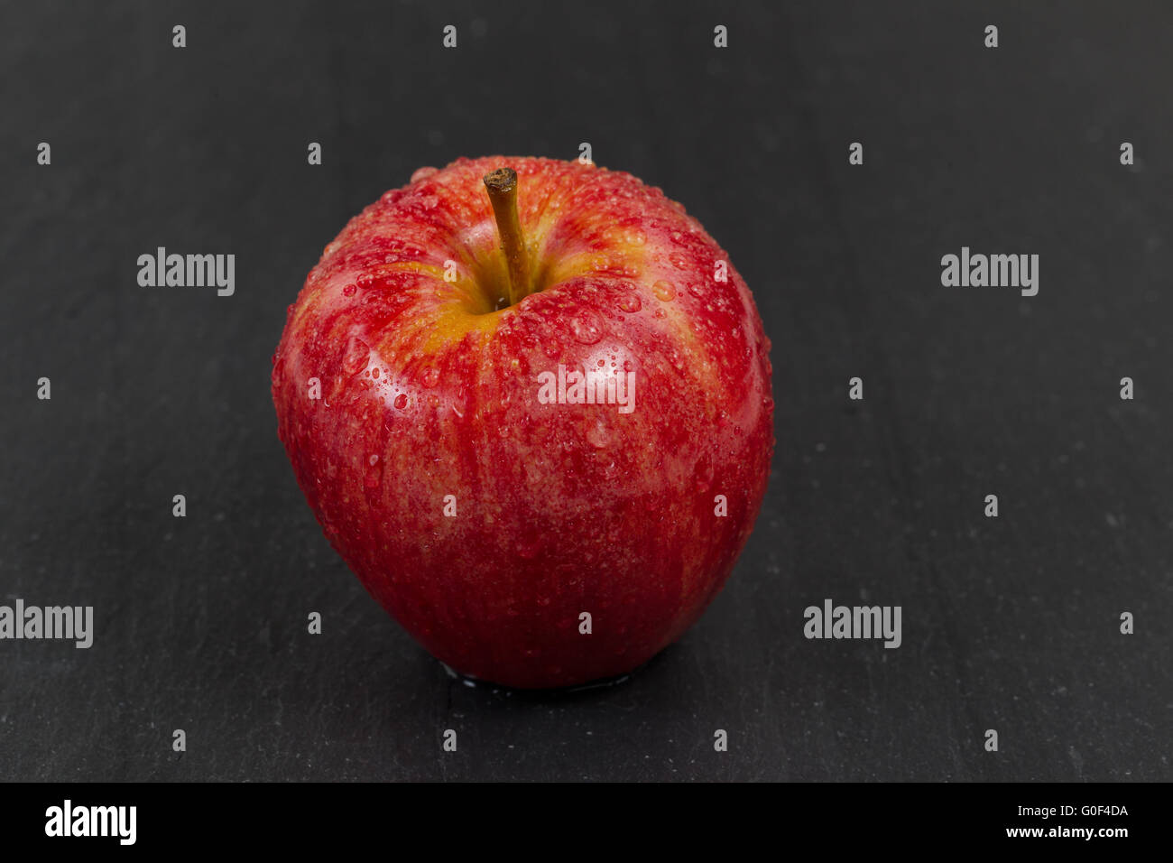 Fresh red whole apple on black slate stone background Stock Photo - Alamy
