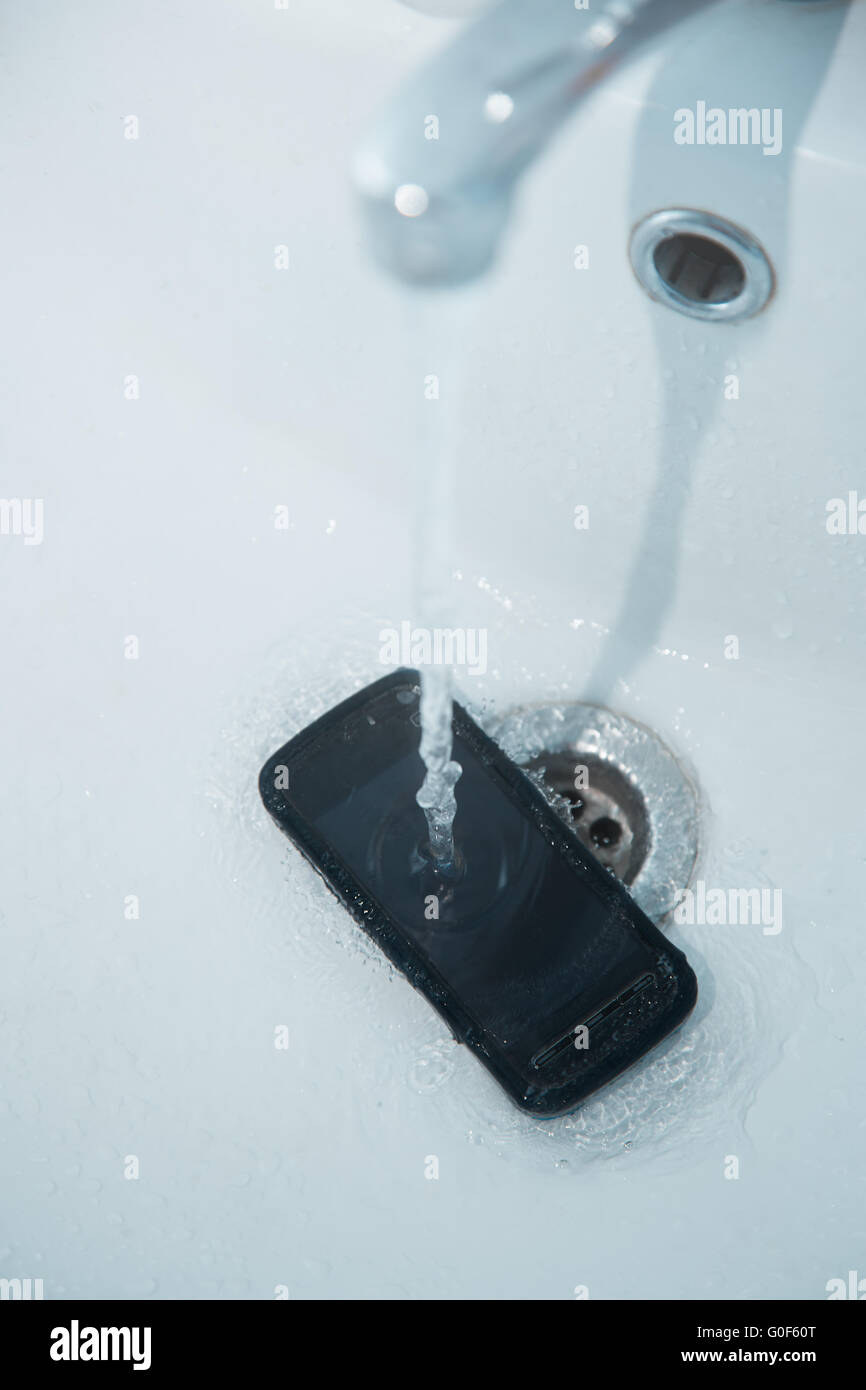 Smartphone in sink with flowing water Stock Photo - Alamy