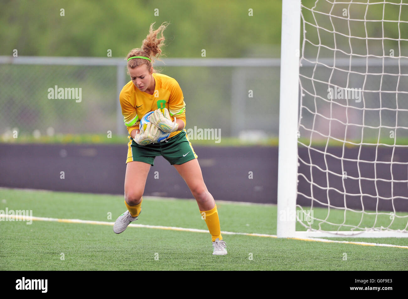 Goal keeper cradling the ball with both hands after making a save on a ...