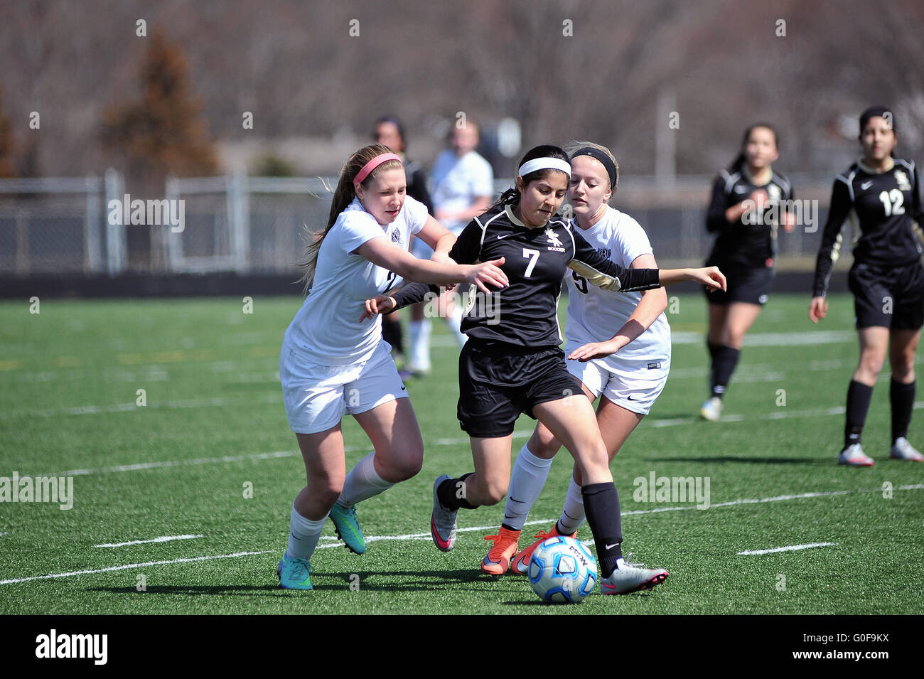 High school forward splitting the defense of a pair of defender while ...