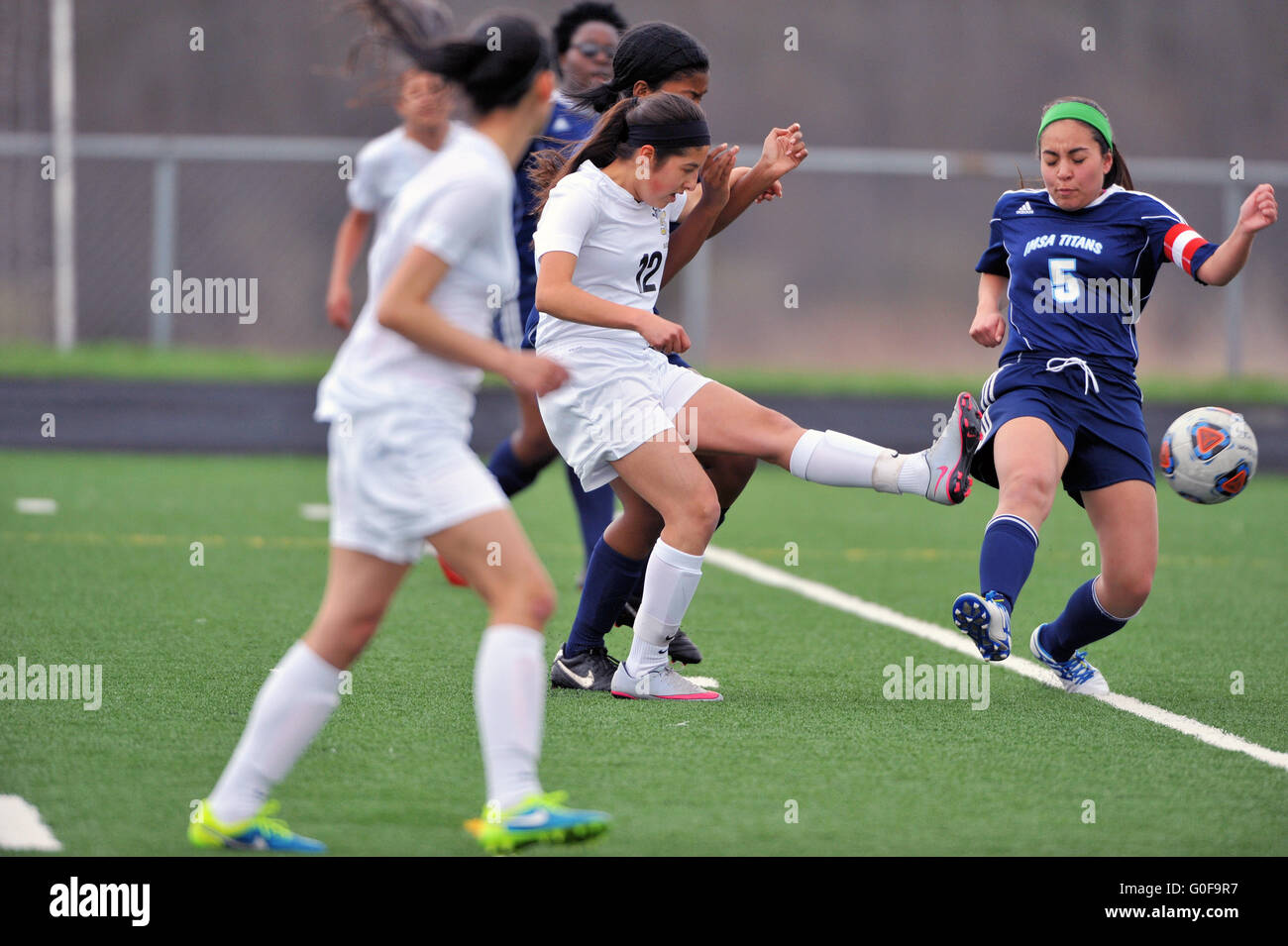 Player getting off a shot near her opponent's goal as a defender ...