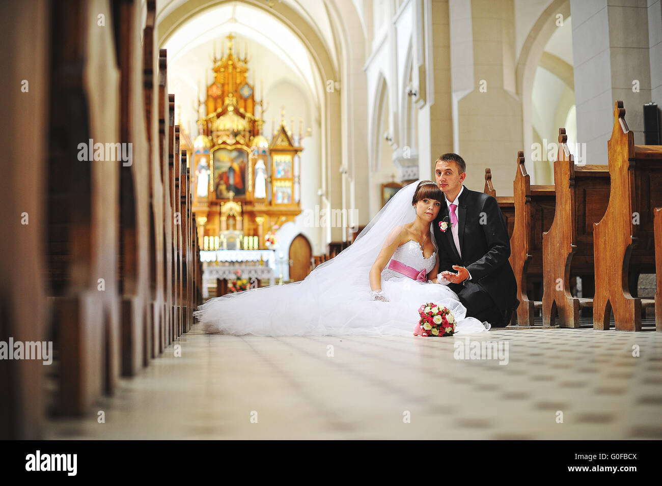 Young beautiful wedding couple at the old catholic church Stock Photo ...