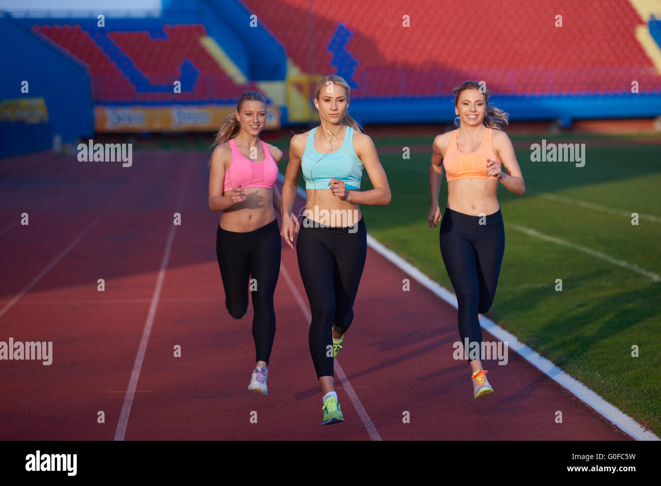 athlete woman group running on athletics race track Stock Photo - Alamy