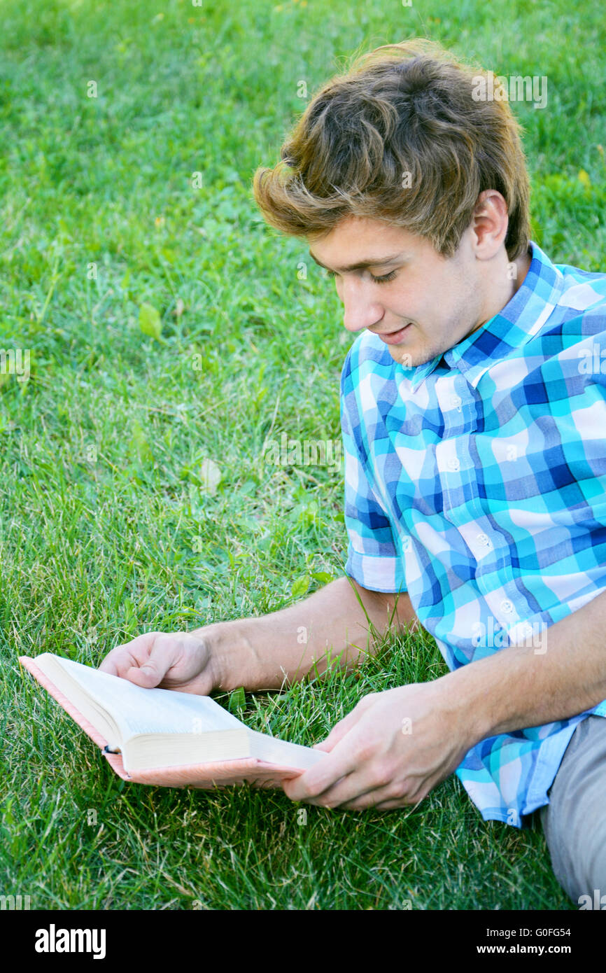 Young man is reading a book Stock Photo - Alamy