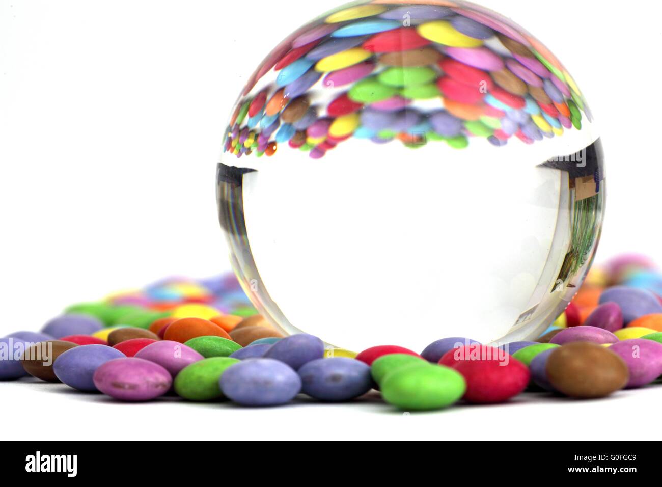 A glass ball with different colored candies Stock Photo - Alamy