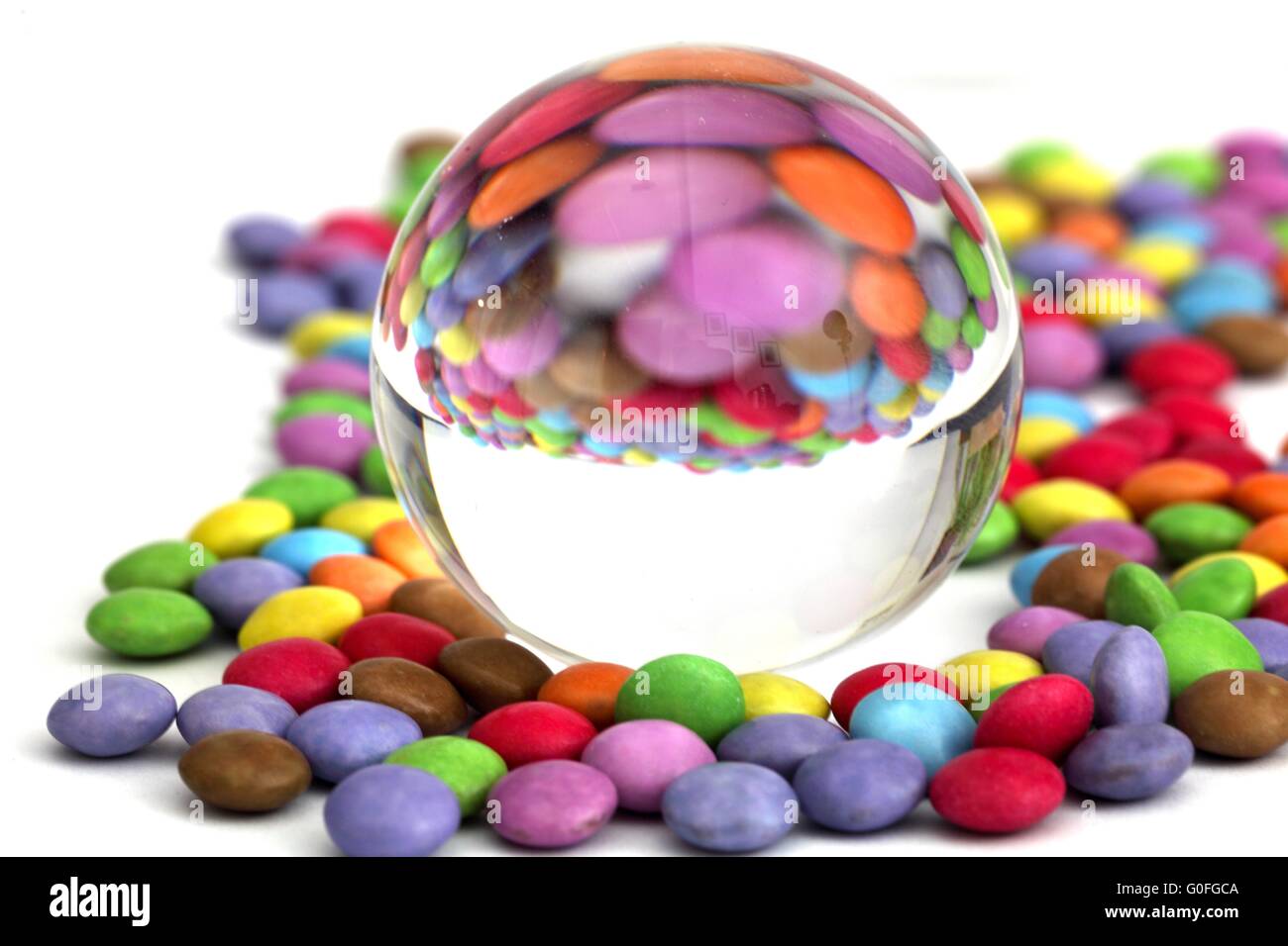 A glass ball with different colored candies Stock Photo - Alamy