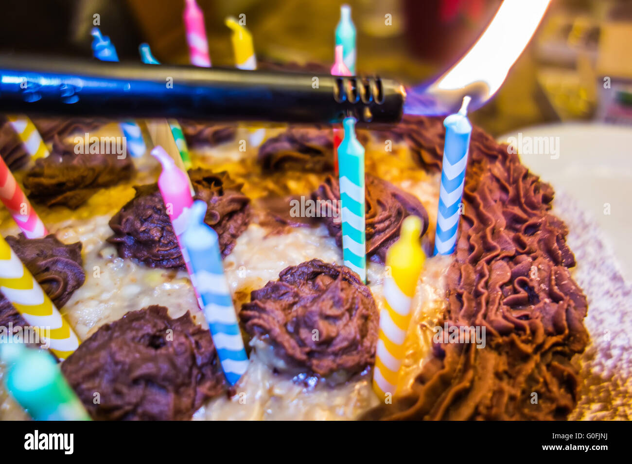 lighting Colorful candles on birthday cake Stock Photo - Alamy