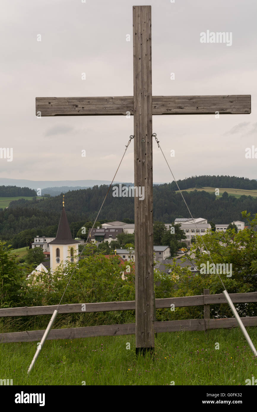 wooden cross stands in front of rural community Stock Photo - Alamy