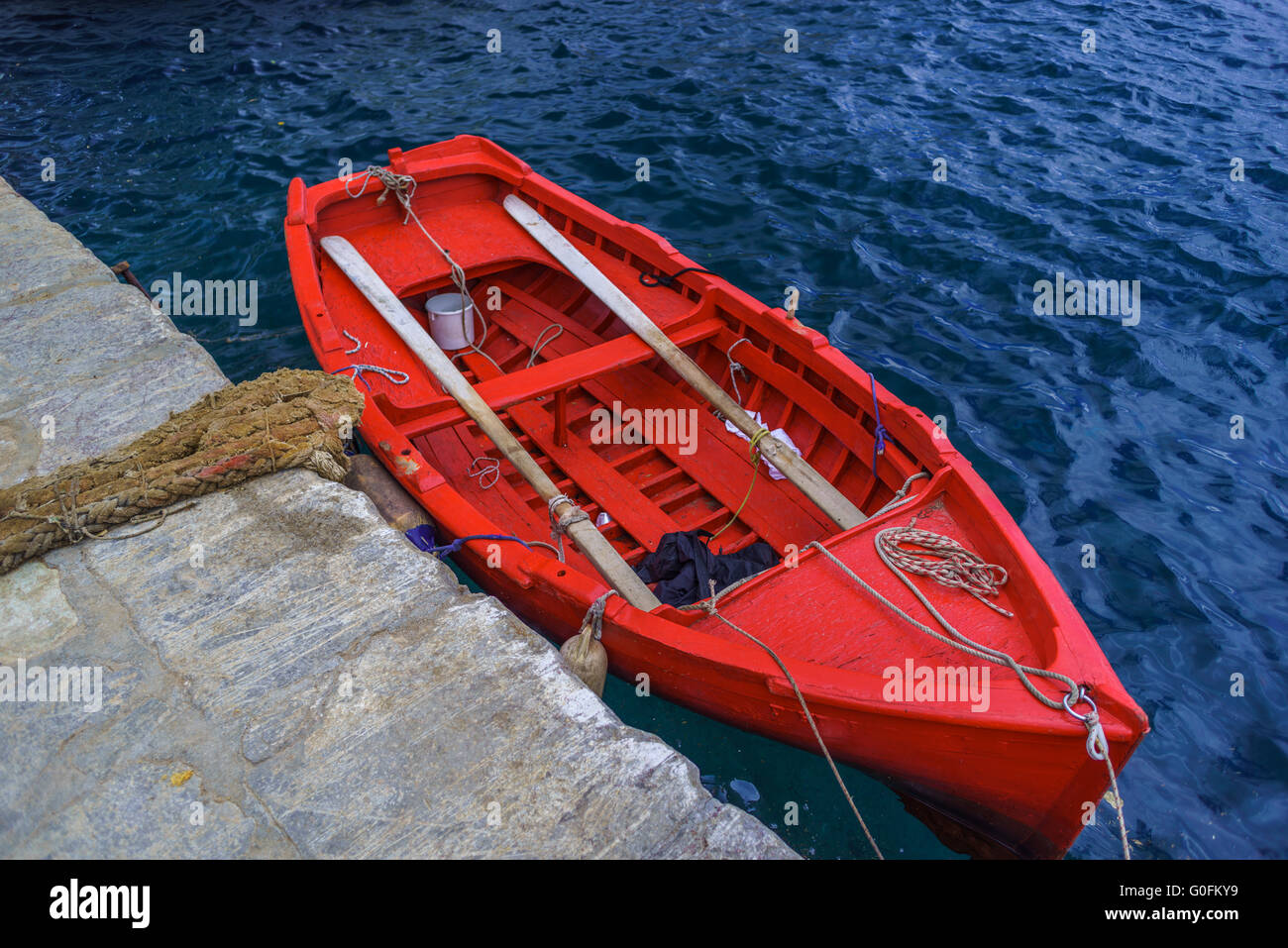 A red dory floats in te blue sea Stock Photo - Alamy