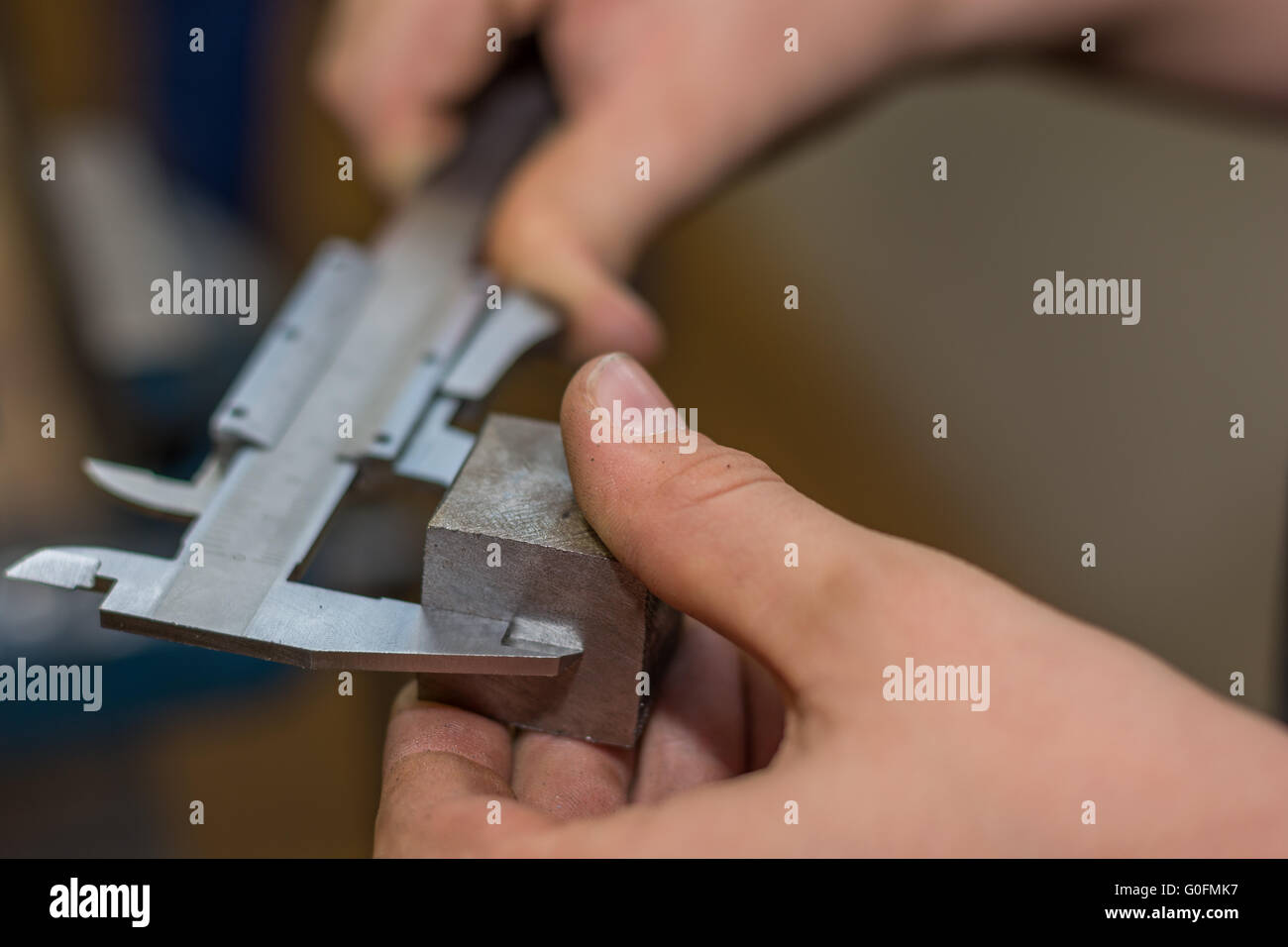 Person measuring with calipers metal piece Stock Photo - Alamy