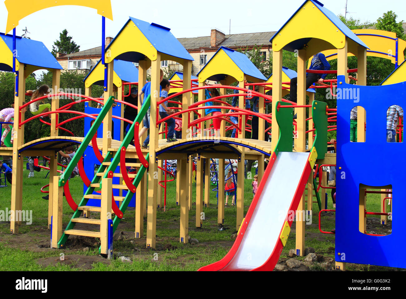 many children playing on the playground with their parents Stock Photo ...