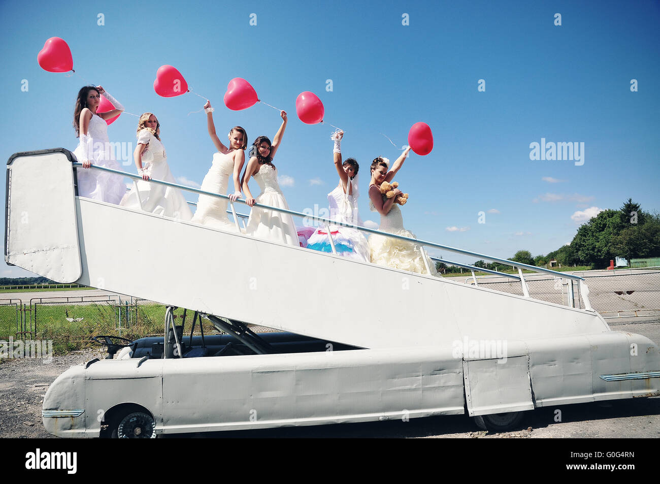 funny brides with balloons at the hand on the airport Stock Photo - Alamy