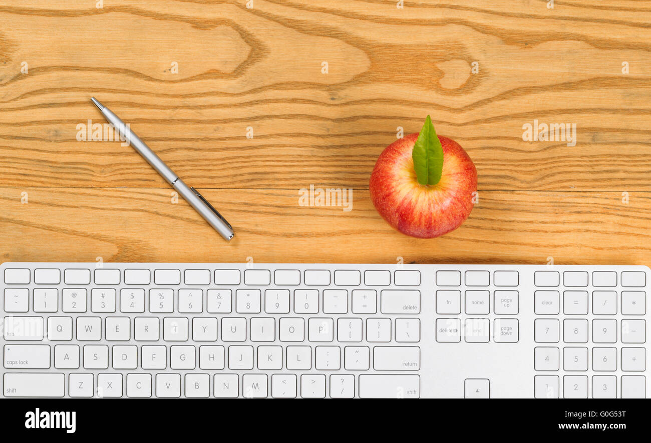 Computer keyboard with pen and apple on desktop Stock Photo - Alamy