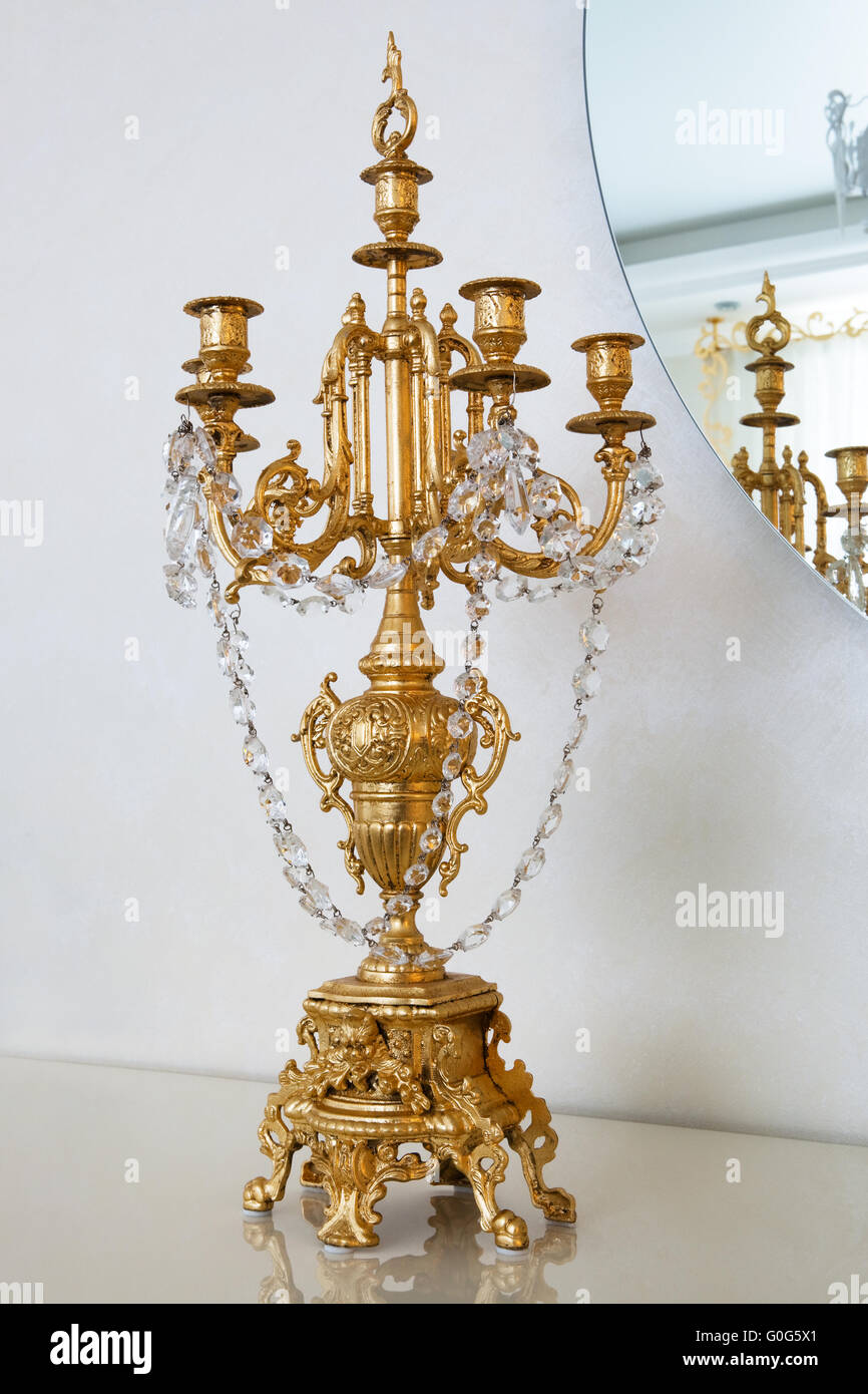 golden candlestick against the wall with the mirror Stock Photo - Alamy