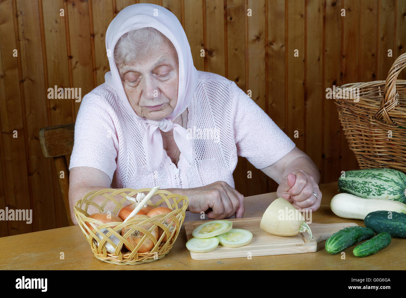 Grandma cuts onions and cucumbers Stock Photo - Alamy
