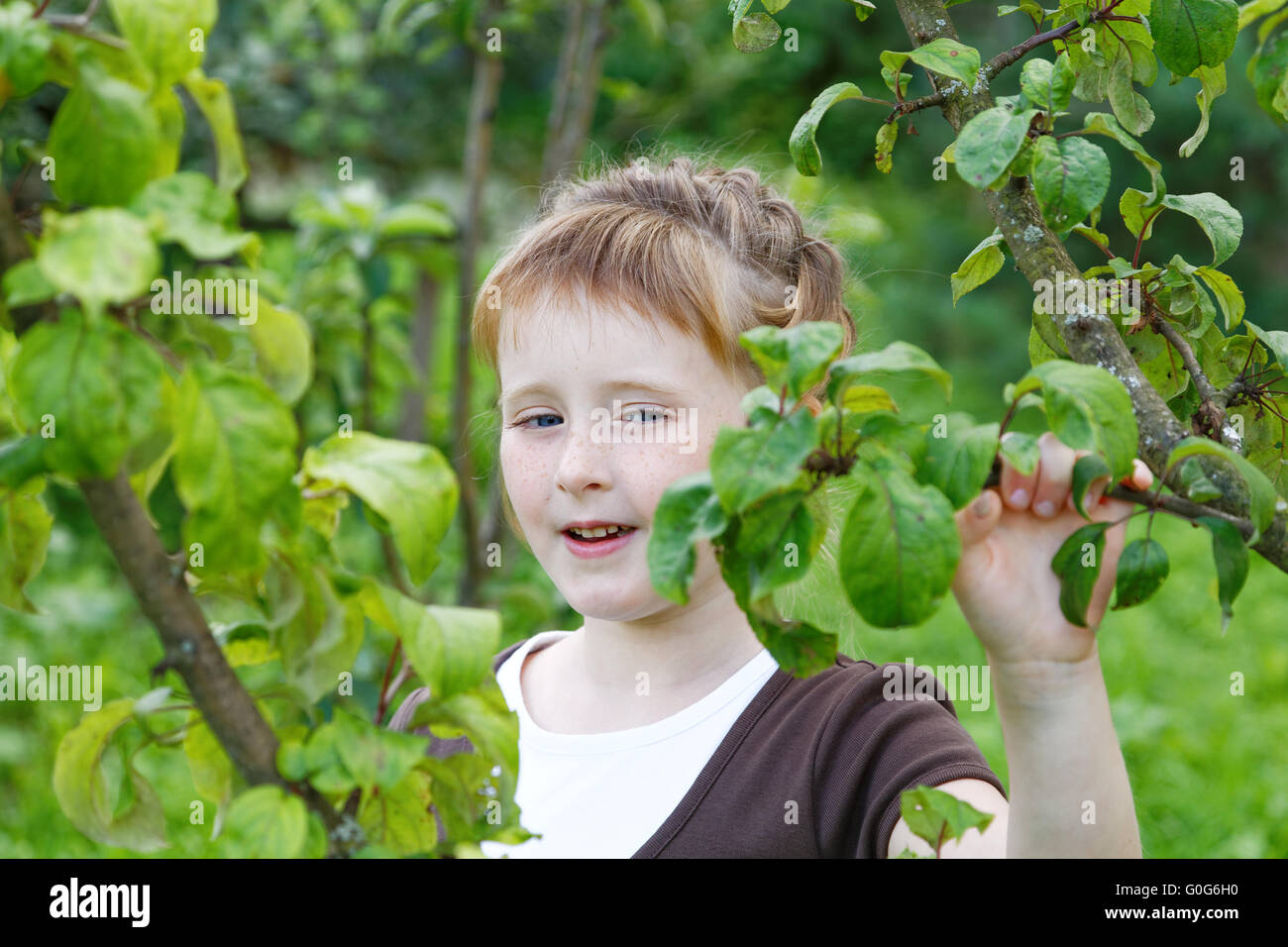 The girl winks one eye against spring foliage Stock Photo - Alamy