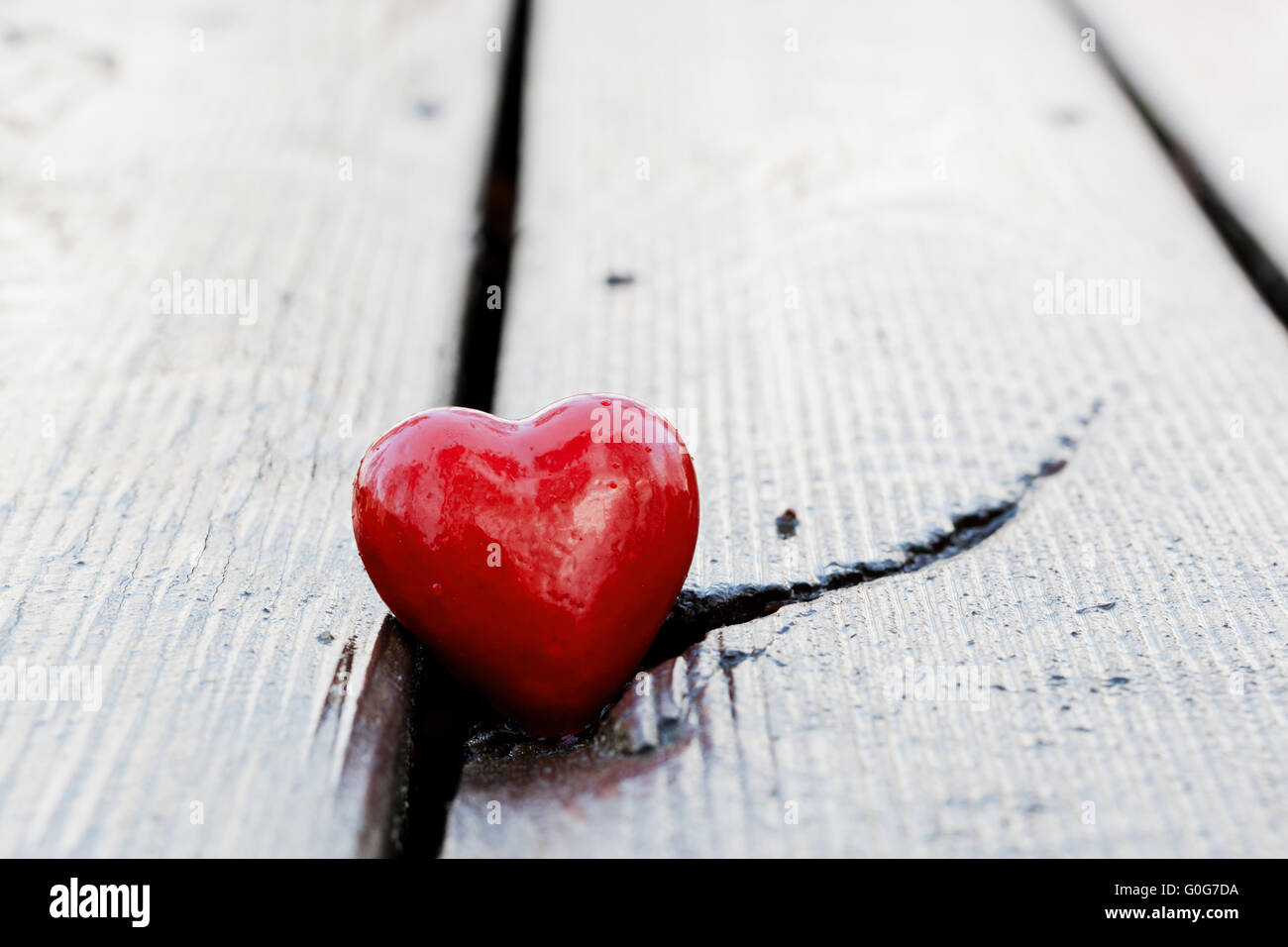 Red heart in crack of wooden plank. Symbol of love Stock Photo - Alamy