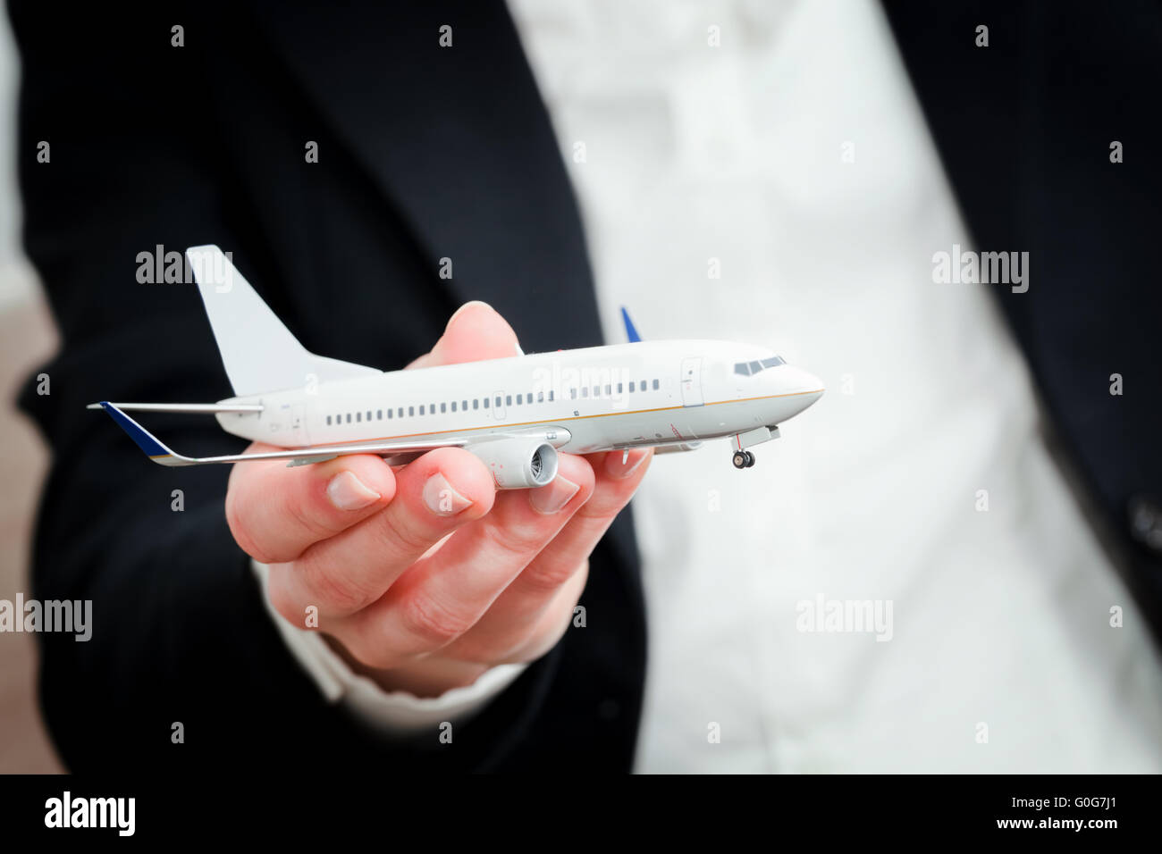 A business person holding an airplane model in hand. Concepts of aerial ...