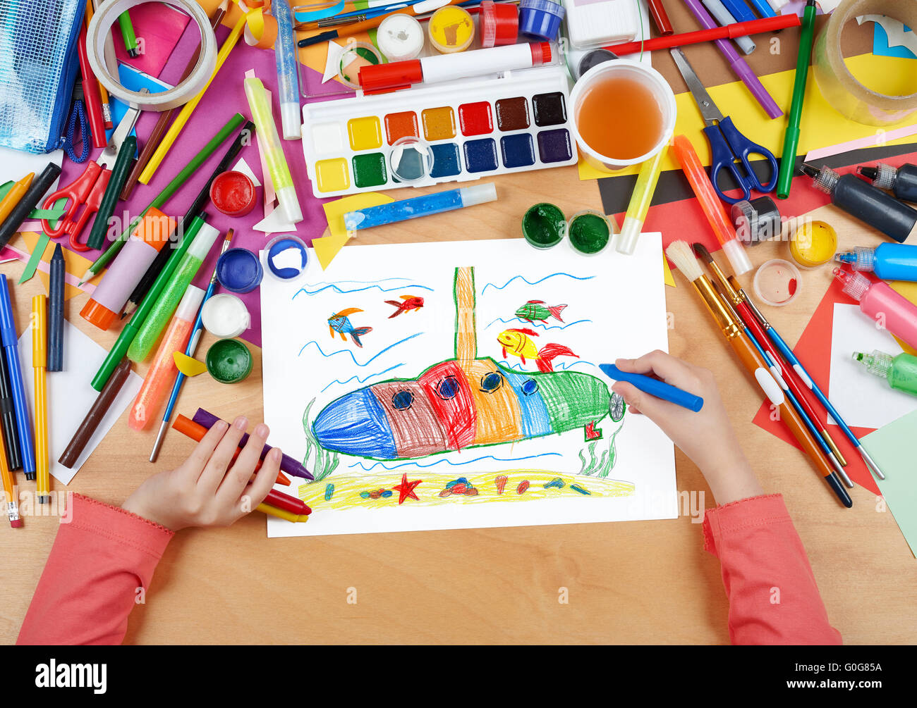 submarine and sea life child drawing , top view hands with pencil ...