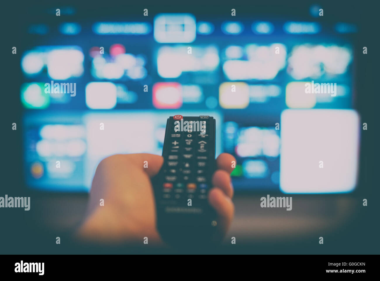 Male hand holding TV remote control Stock Photo - Alamy