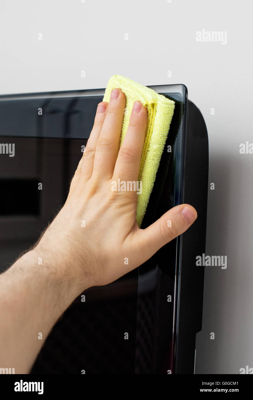 Man's hand wipes dust from TV panel Stock Photo - Alamy