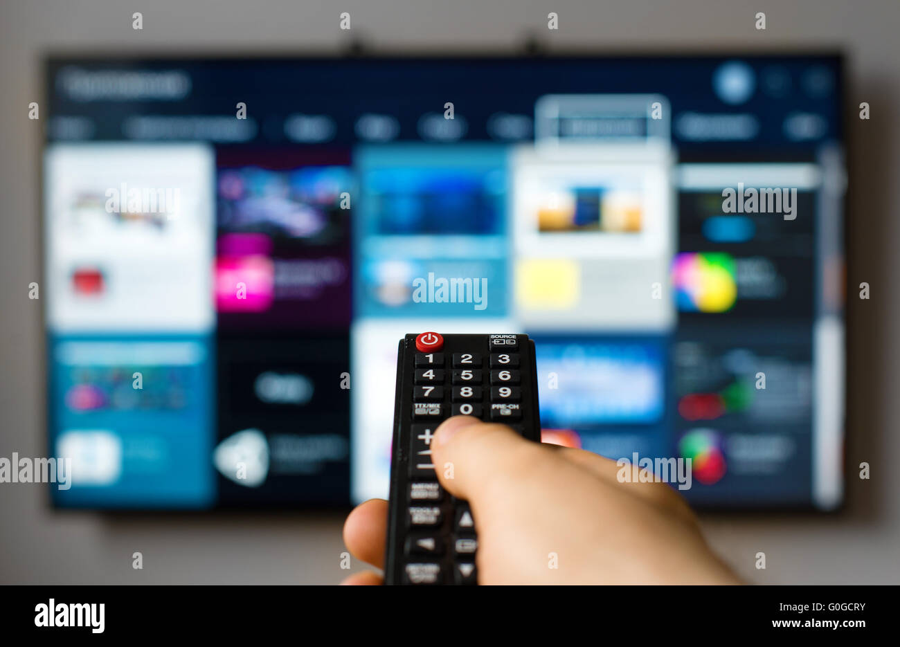 Male hand holding TV remote control Stock Photo - Alamy