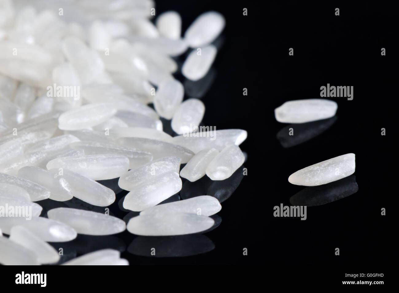 Close-up white grains of rice on black mirrored surface Stock Photo - Alamy