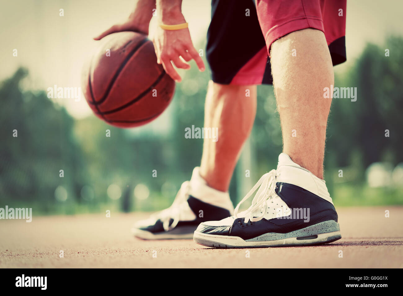Young man on basketball court dribbling with ball. Streetball Stock ...