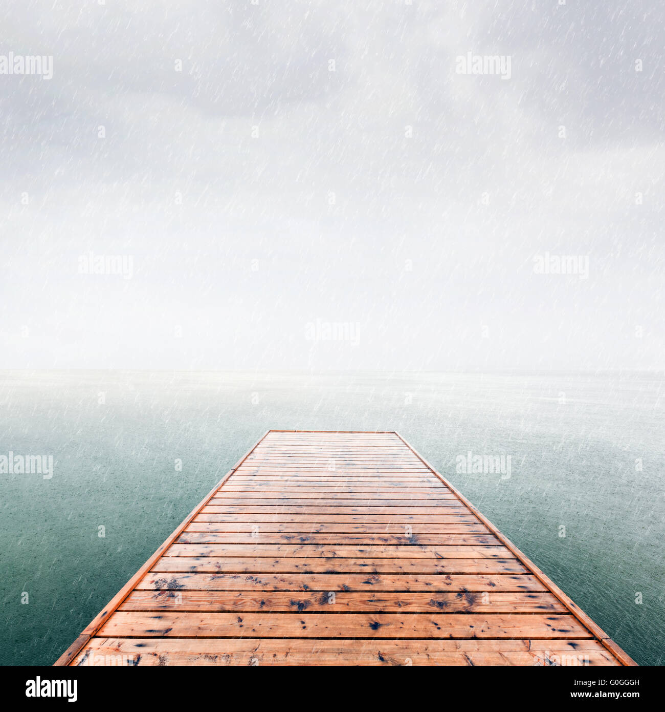 Wooden jetty, pier on deep cold sea, ocean. Raining sky Stock Photo - Alamy