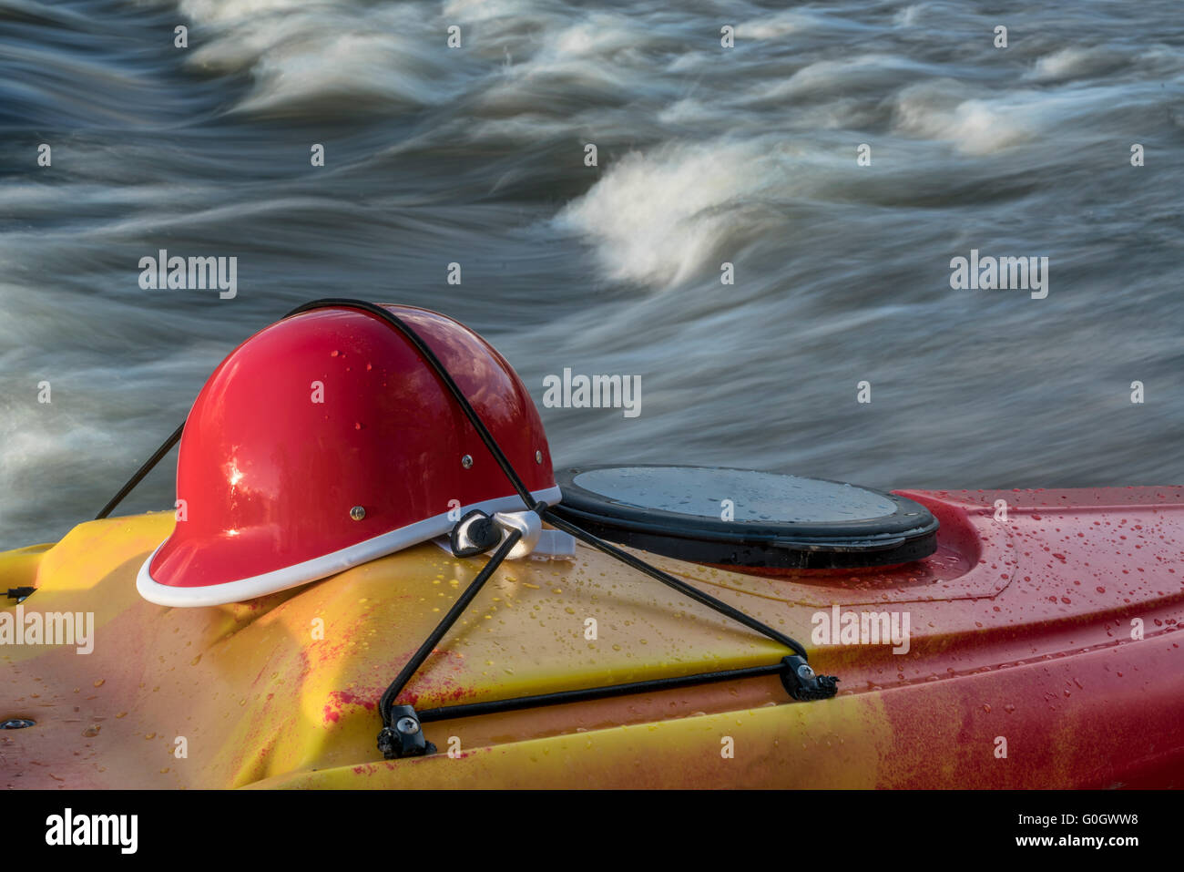 whitewater kayaking helmet on a kayak deck against river rapid Stock ...