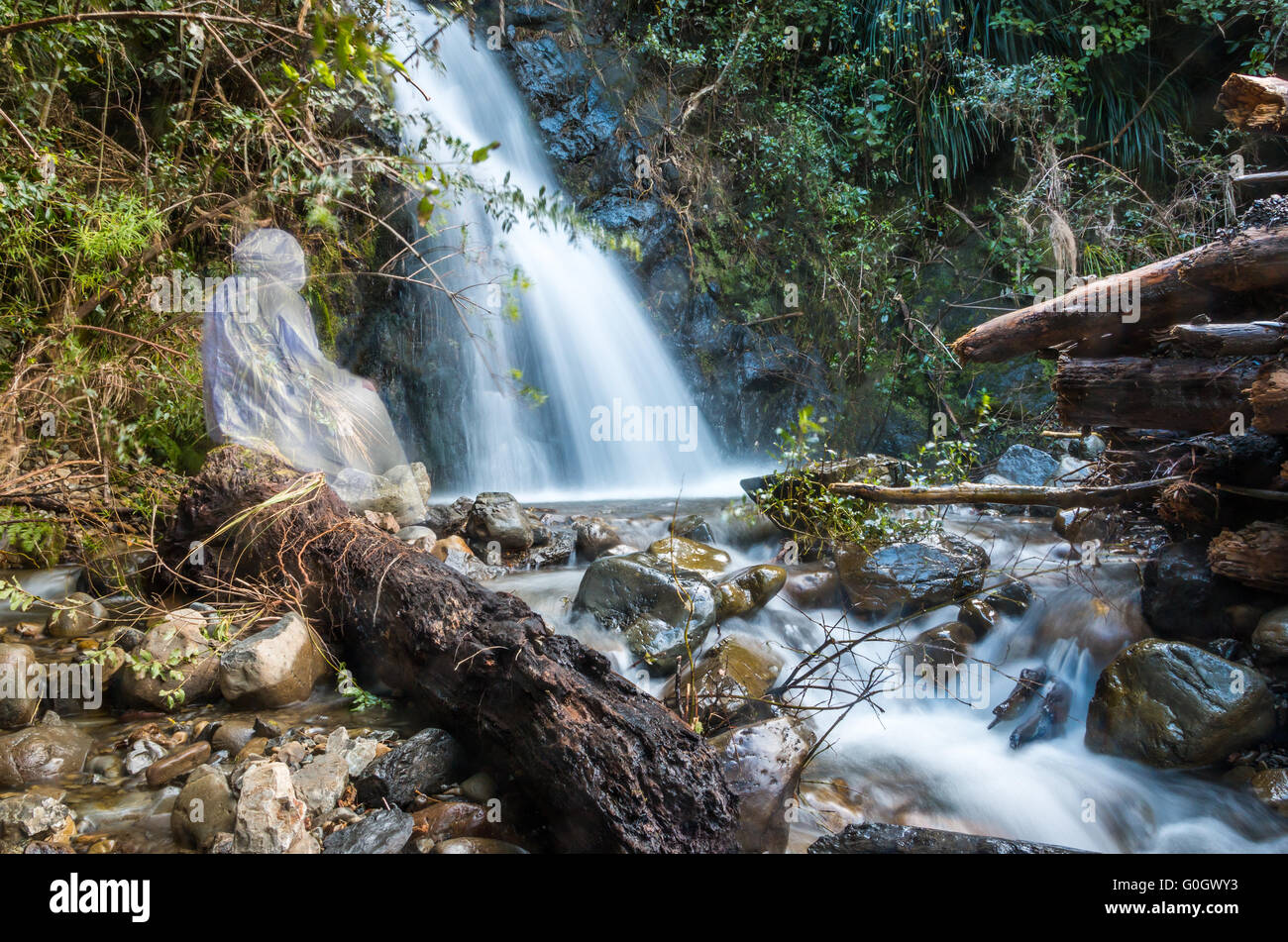 Ghost image of Jesus Christ sitting on a log by a wonderful waterfall ...