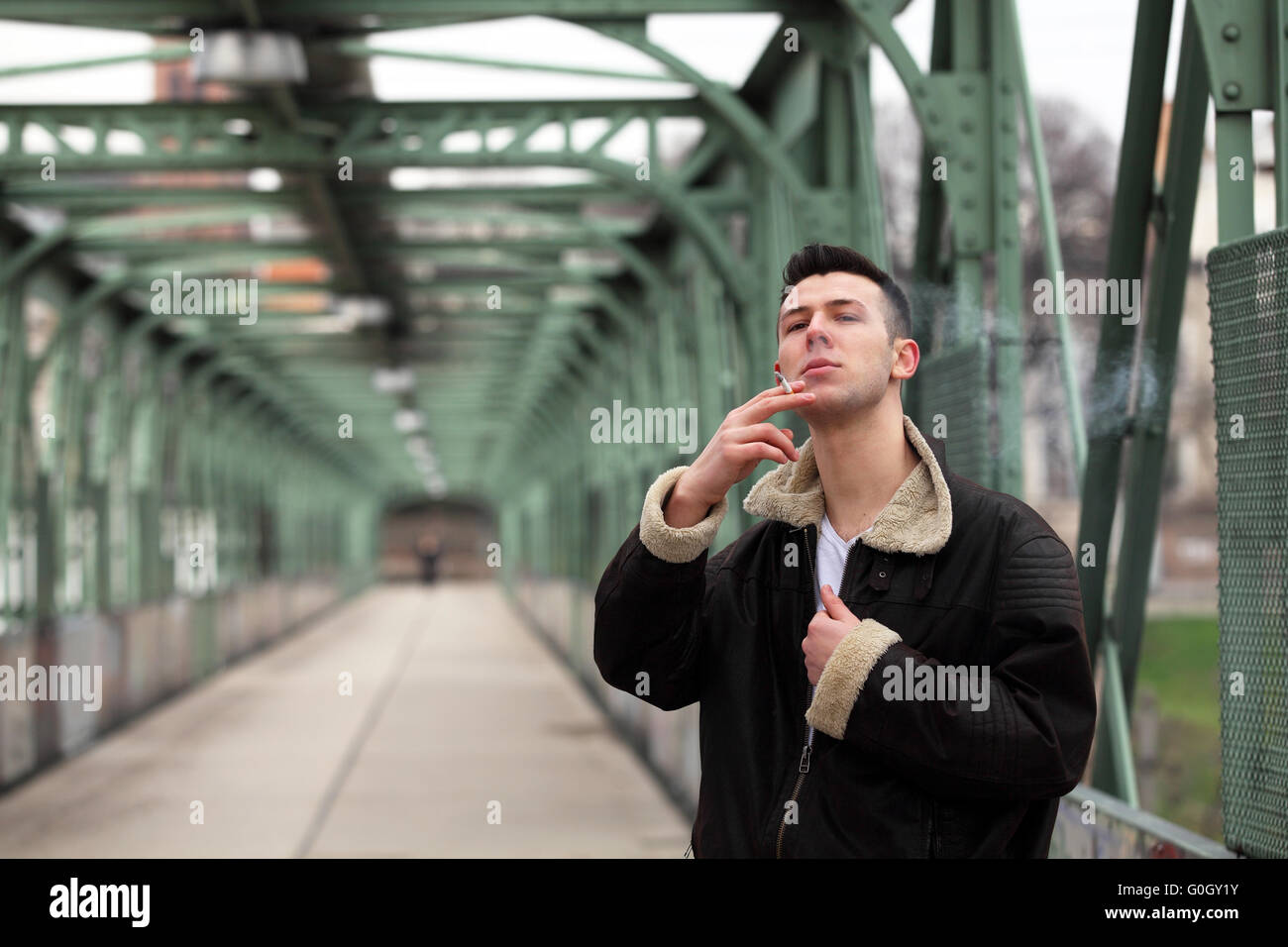 Attractive young man smoking a cigarette on the street Stock Photo - Alamy