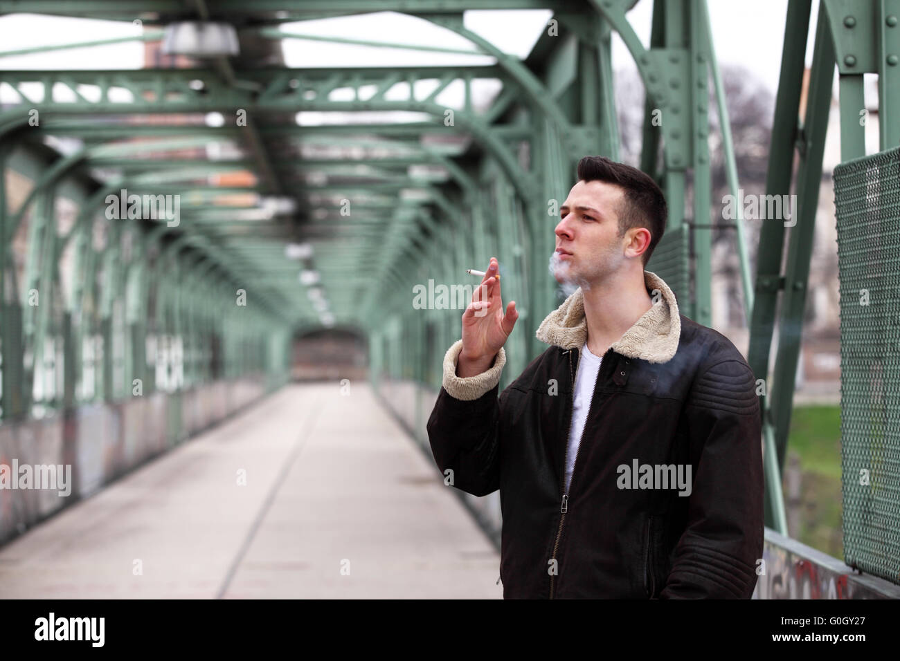 Attractive young man smoking a cigarette on the street Stock Photo - Alamy
