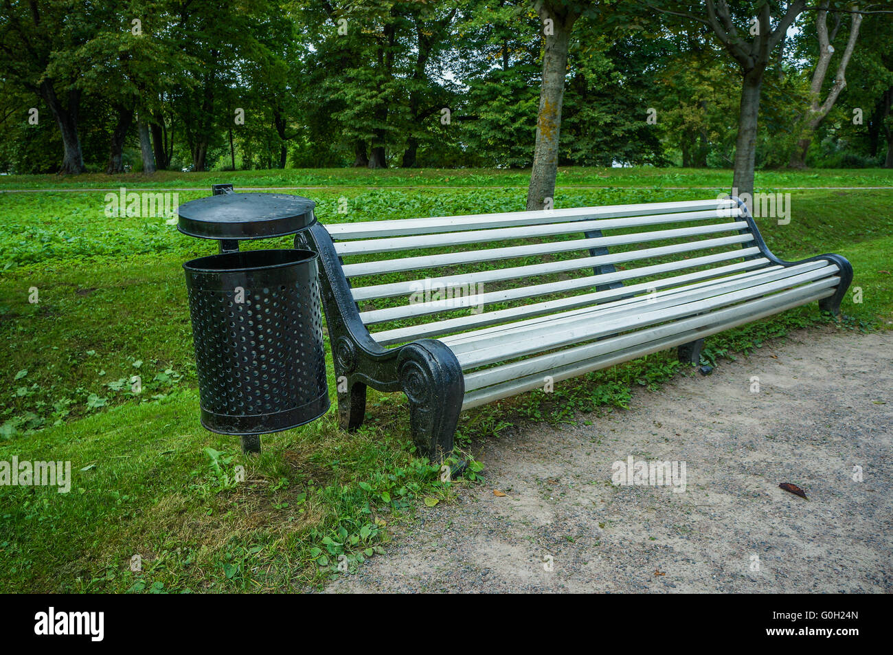 Bench for rest in the park and litter box Stock Photo - Alamy