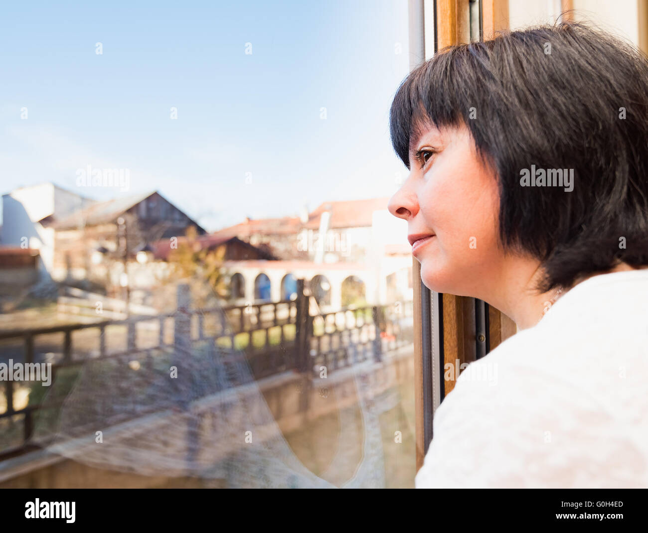 brunette woman looking out the window Stock Photo - Alamy