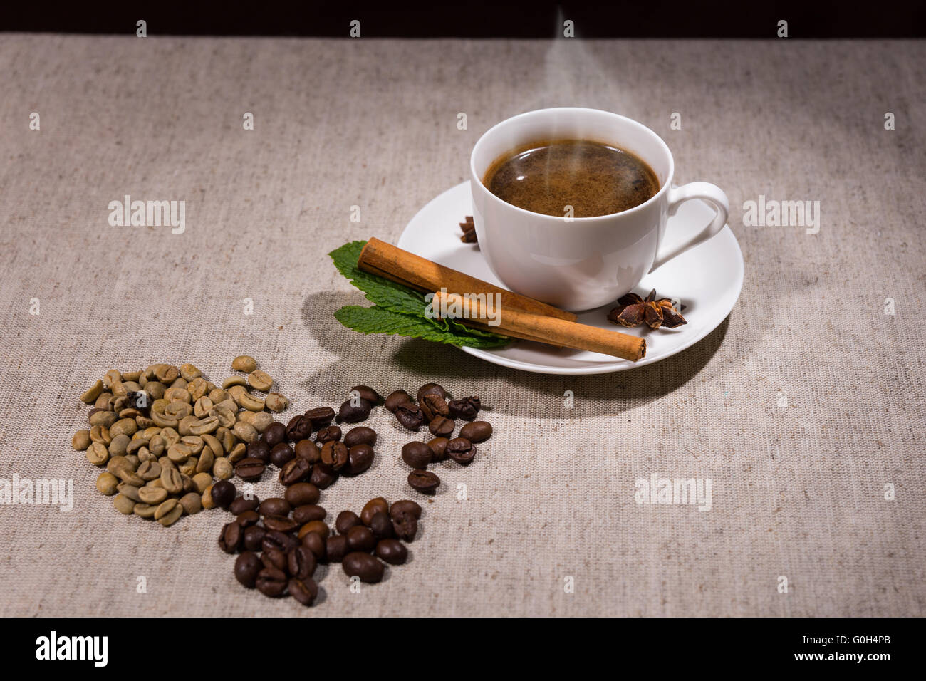 Pile of two types of different java beans and herbs beside steaming hot ...