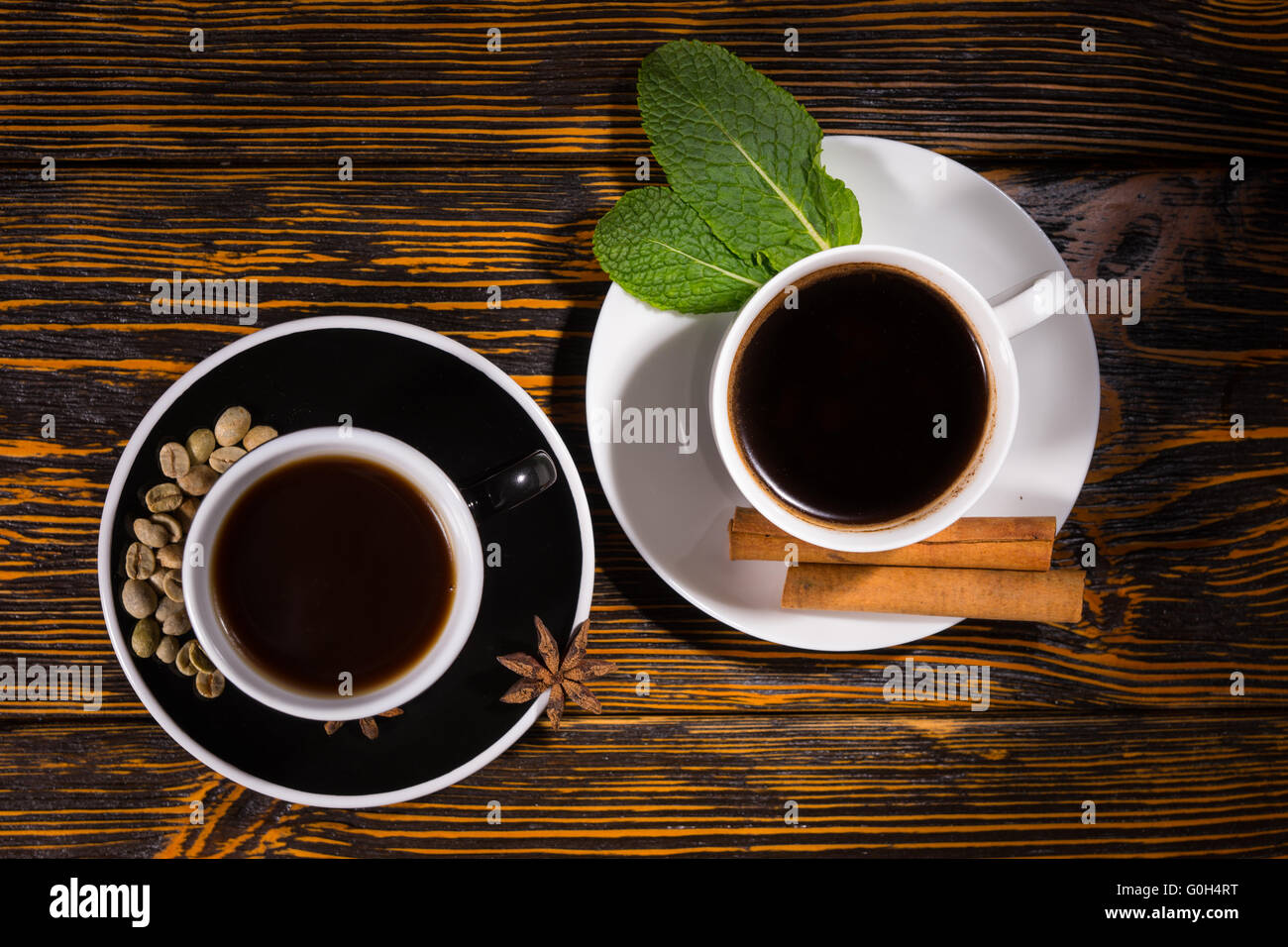 Top down view on servings of coffee and tea in cups with beans, spices ...