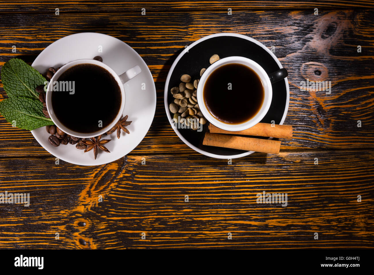 Top down view of black tea and coffee garnished with leaves, beans and ...