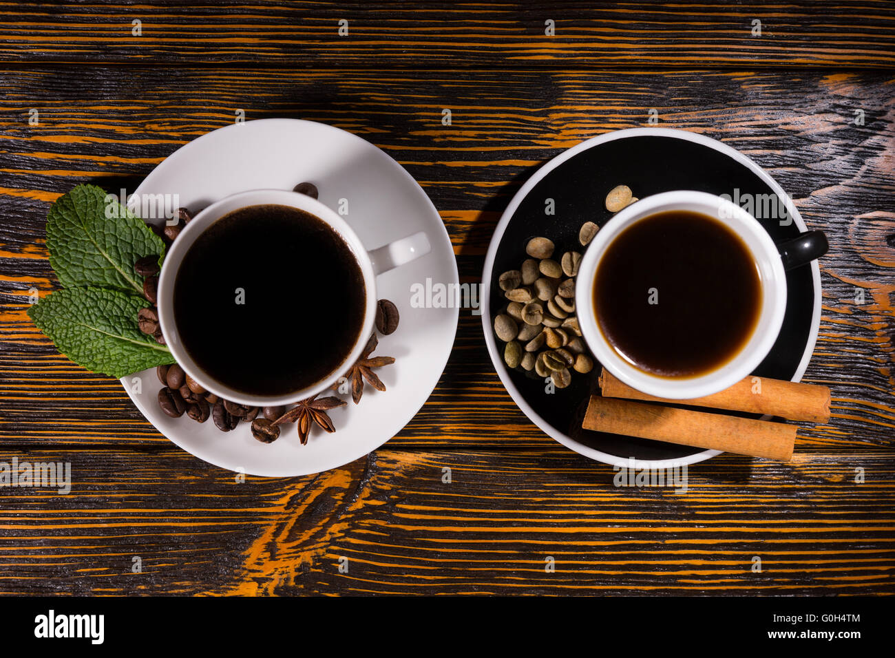 Top down view of black coffee and tea with leaves, beans and cinnamon ...