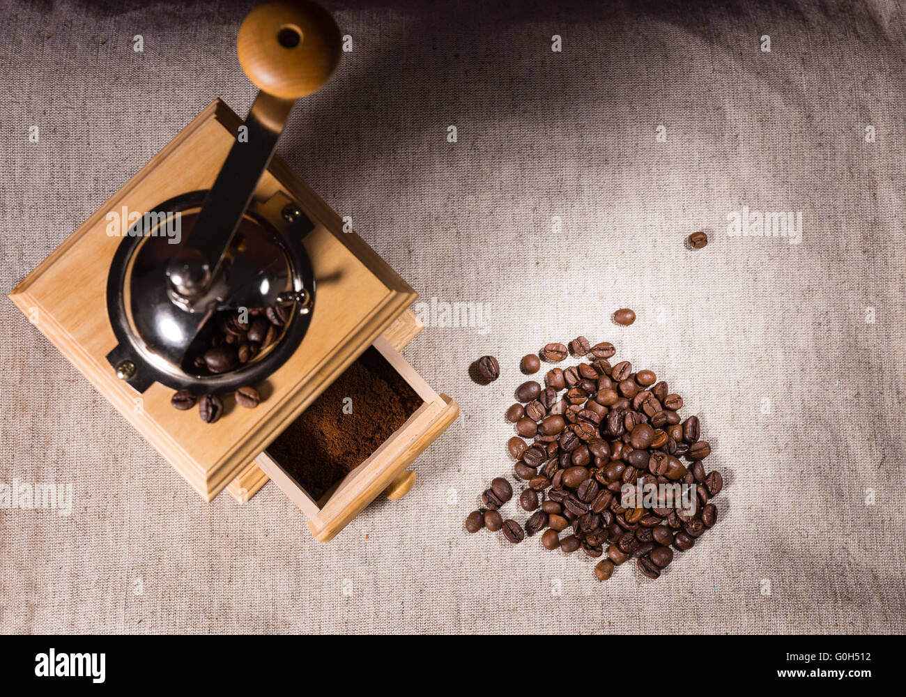 Top down view on square shaped wooden coffee grinder, grounds and small ...