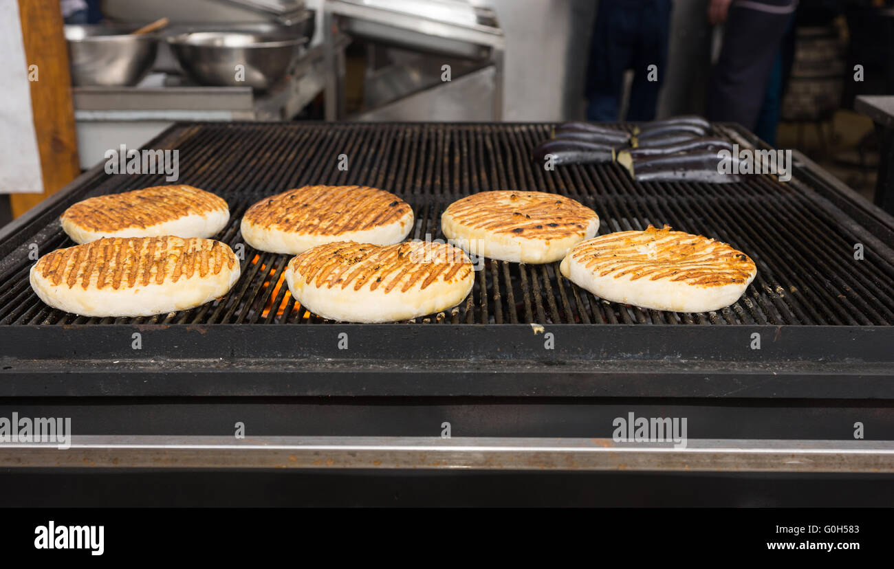 Buns for burgers grilling over a fire in a commercial kitchen ready for ...