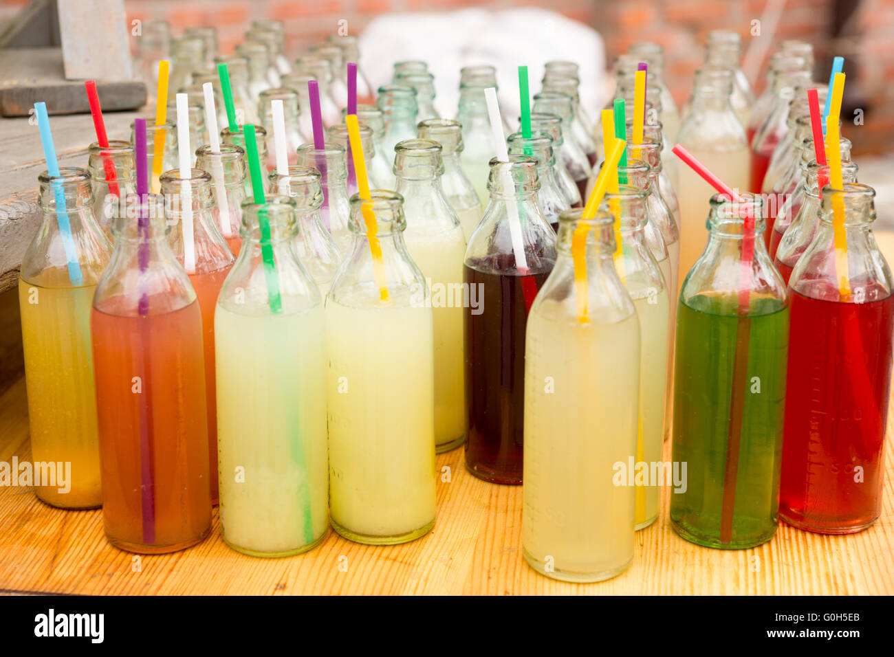 Assortment of fresh fruit juice for sale in opened glass bottles with ...