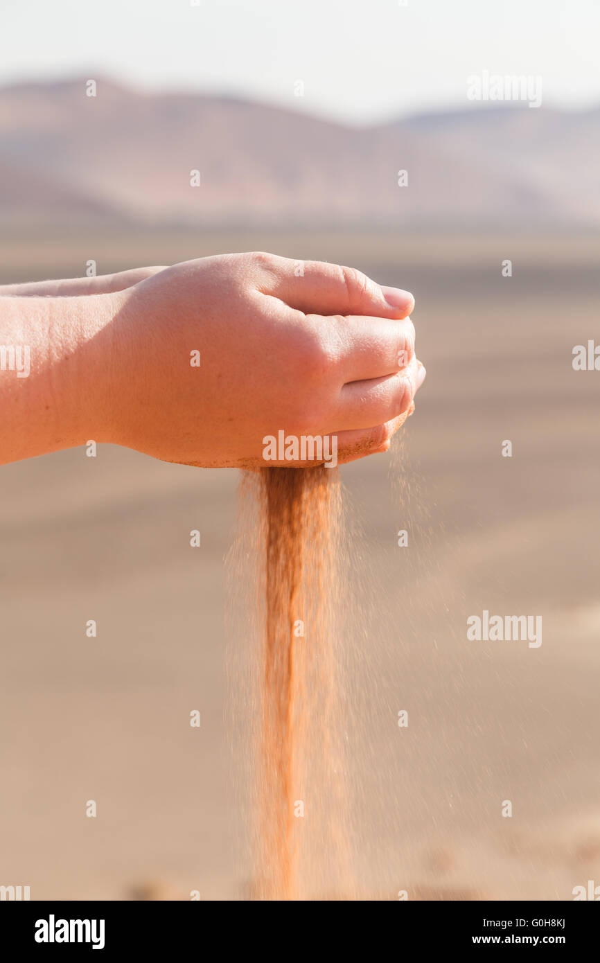 Sand running through hands. Time running out Stock Photo - Alamy