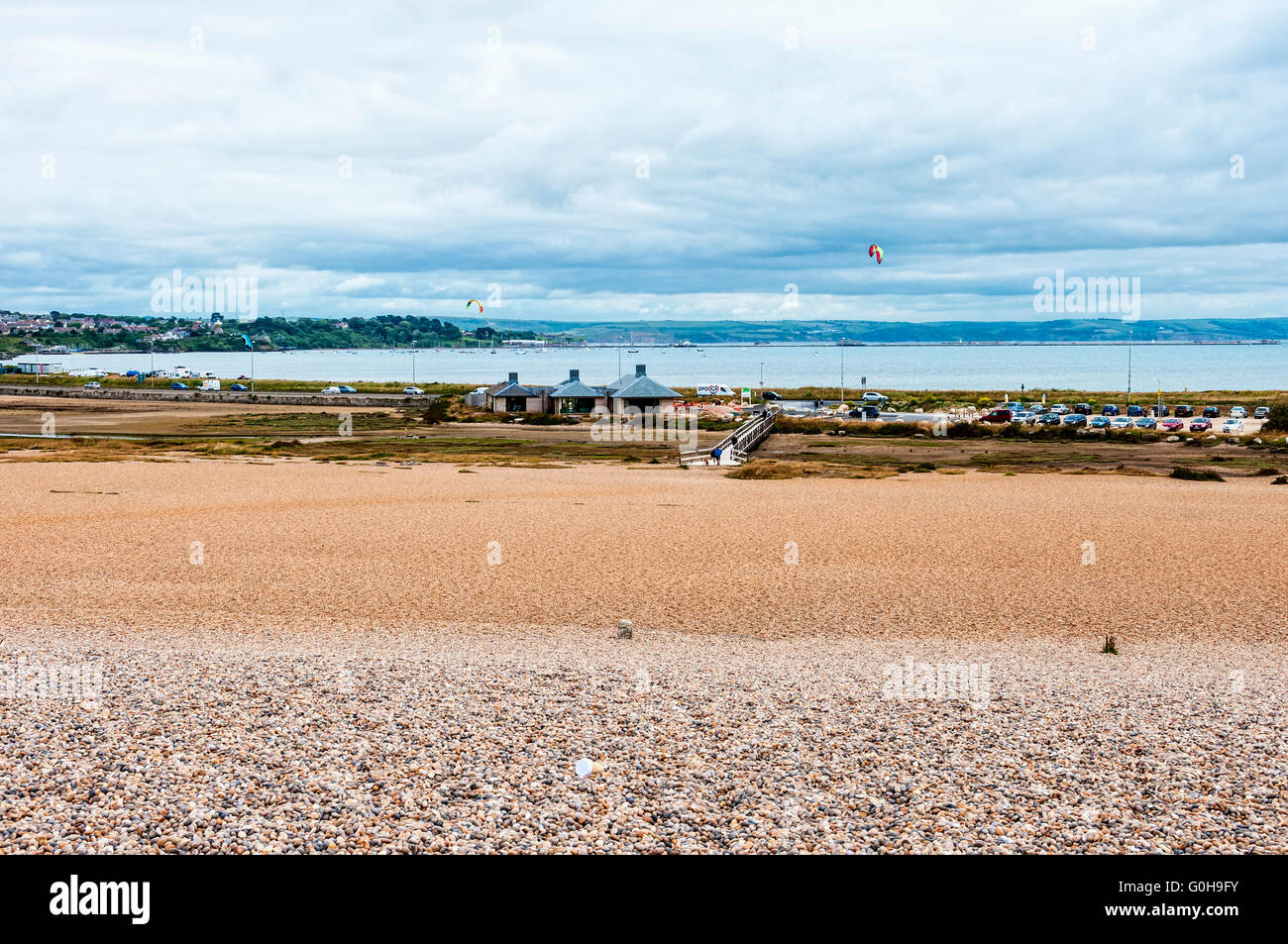 A wide beach of rounded coloured flint and chert pebbles nearly reaches ...