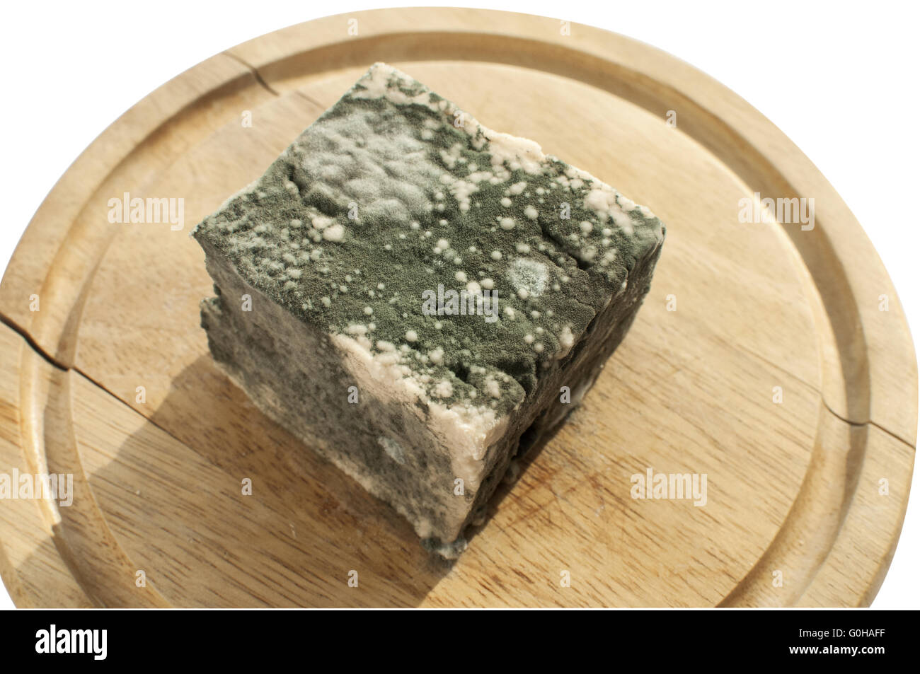 Moldy lump of white cheese on wooden tray isolated on white background ...