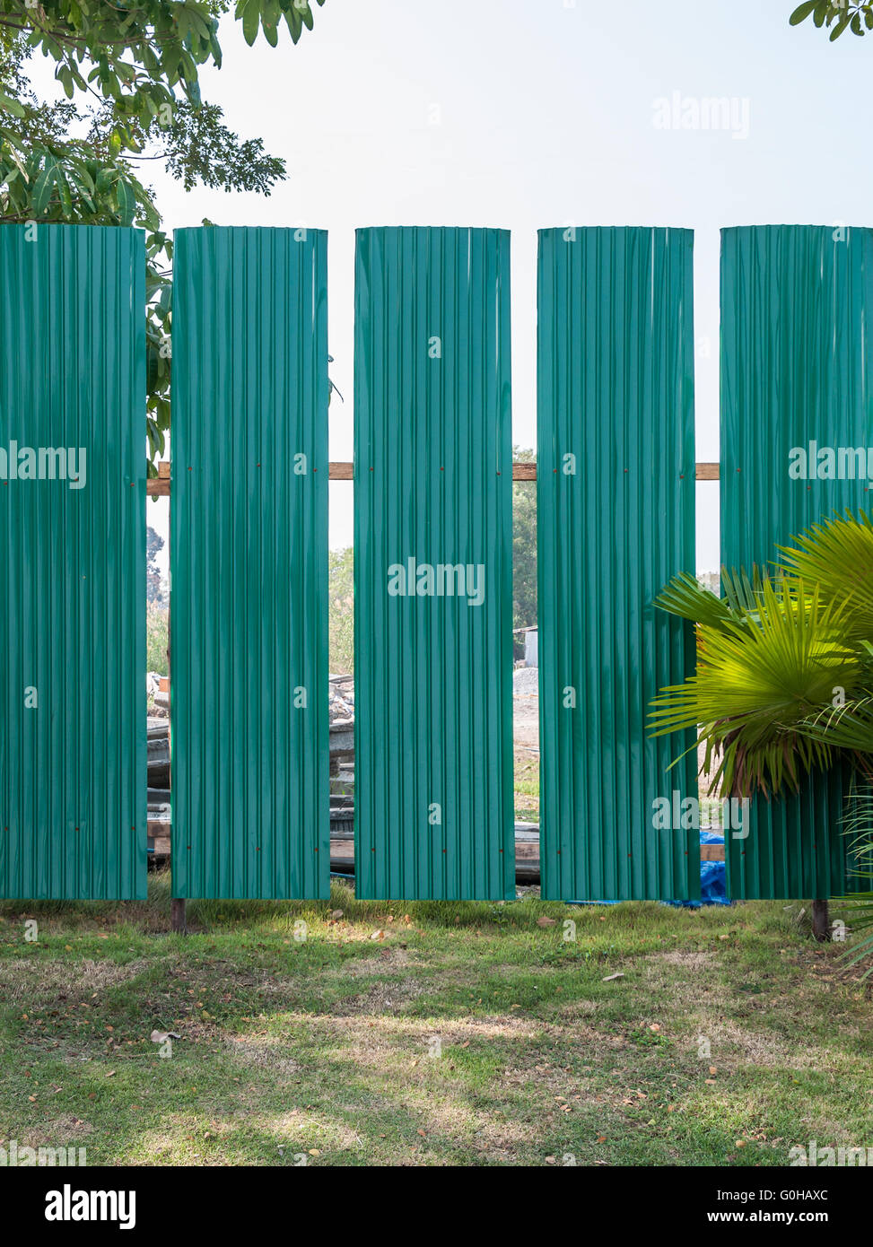 Green metal fence for safety of the construction site in urban park ...