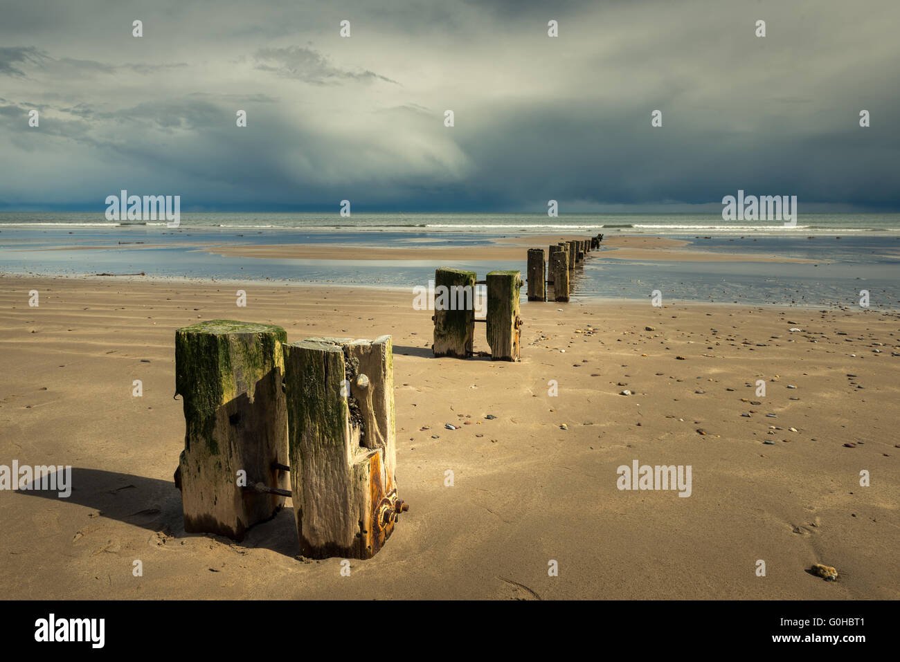 Ireland beach and jetty remains groynes on the empty Youghal beach in ...