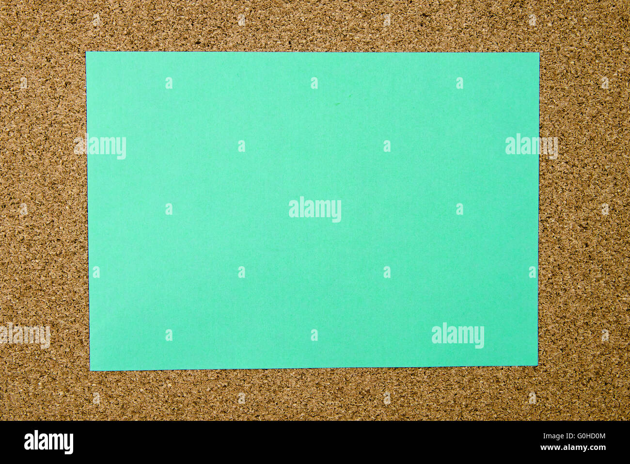 Blank turquoise paper note over cork board background, copy space ...