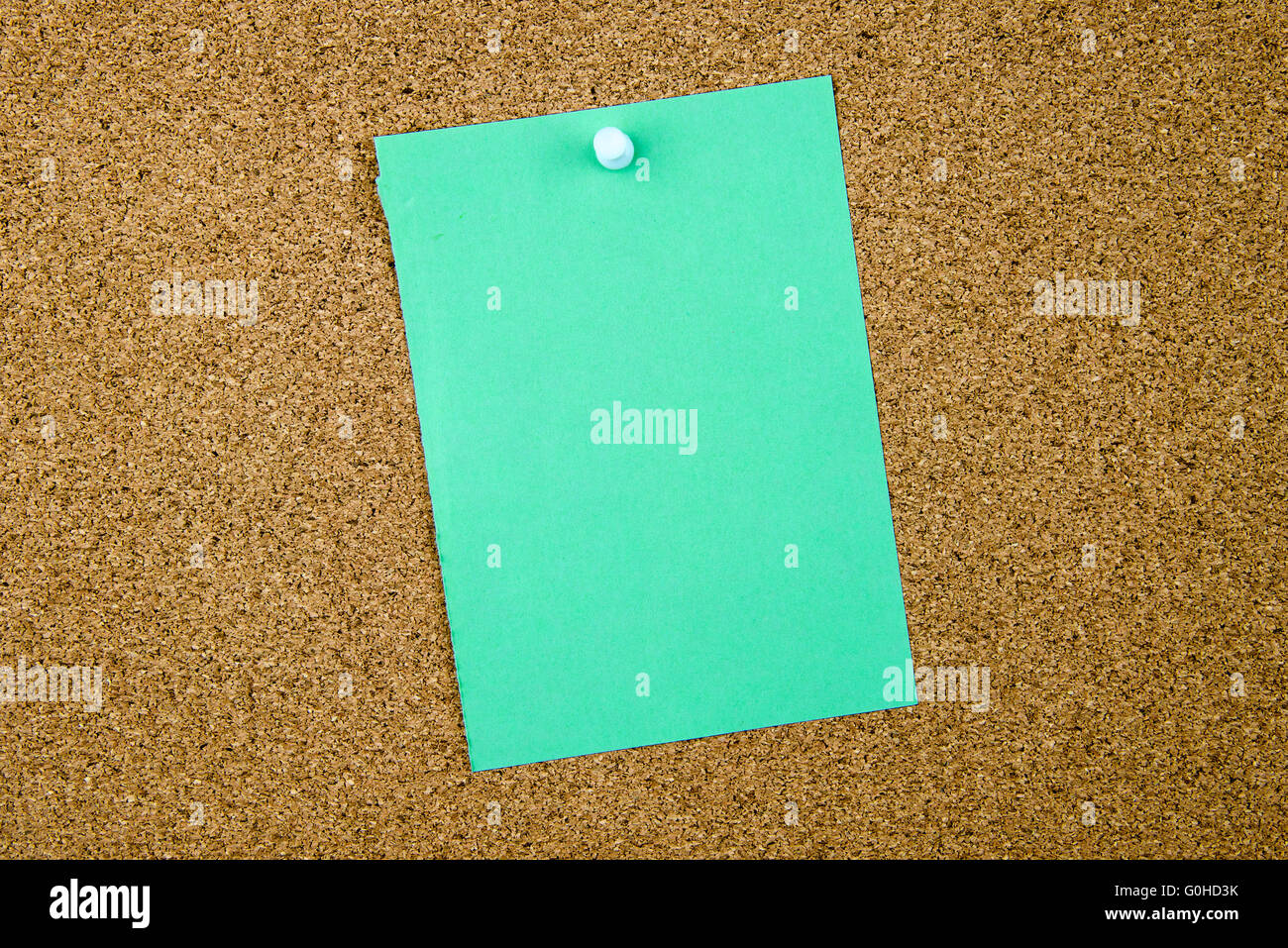 Blank turquoise paper note pinned on cork board with red thumbtack ...